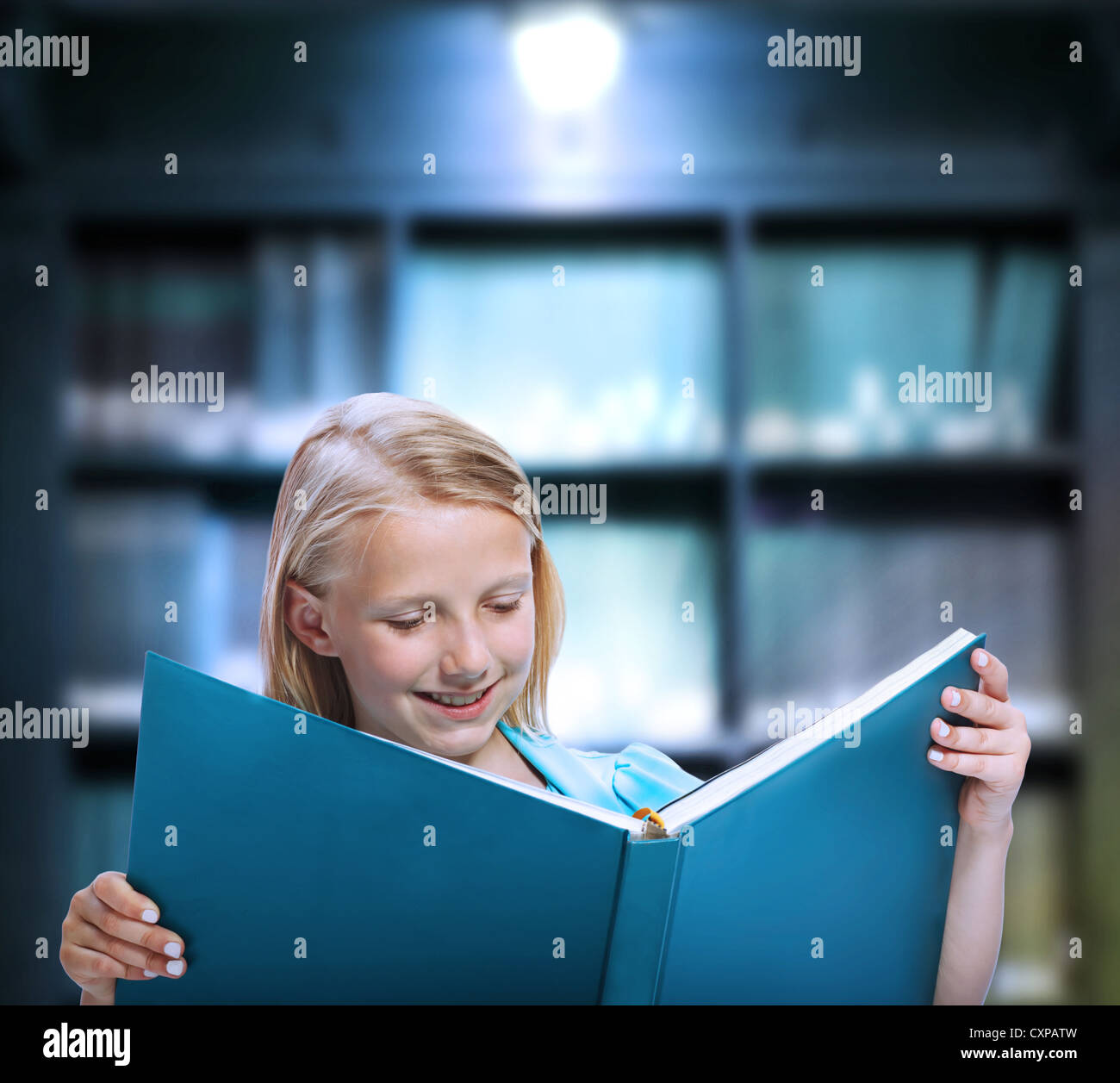 Little Girl Reading a Big Book in a Library Stock Photo - Alamy