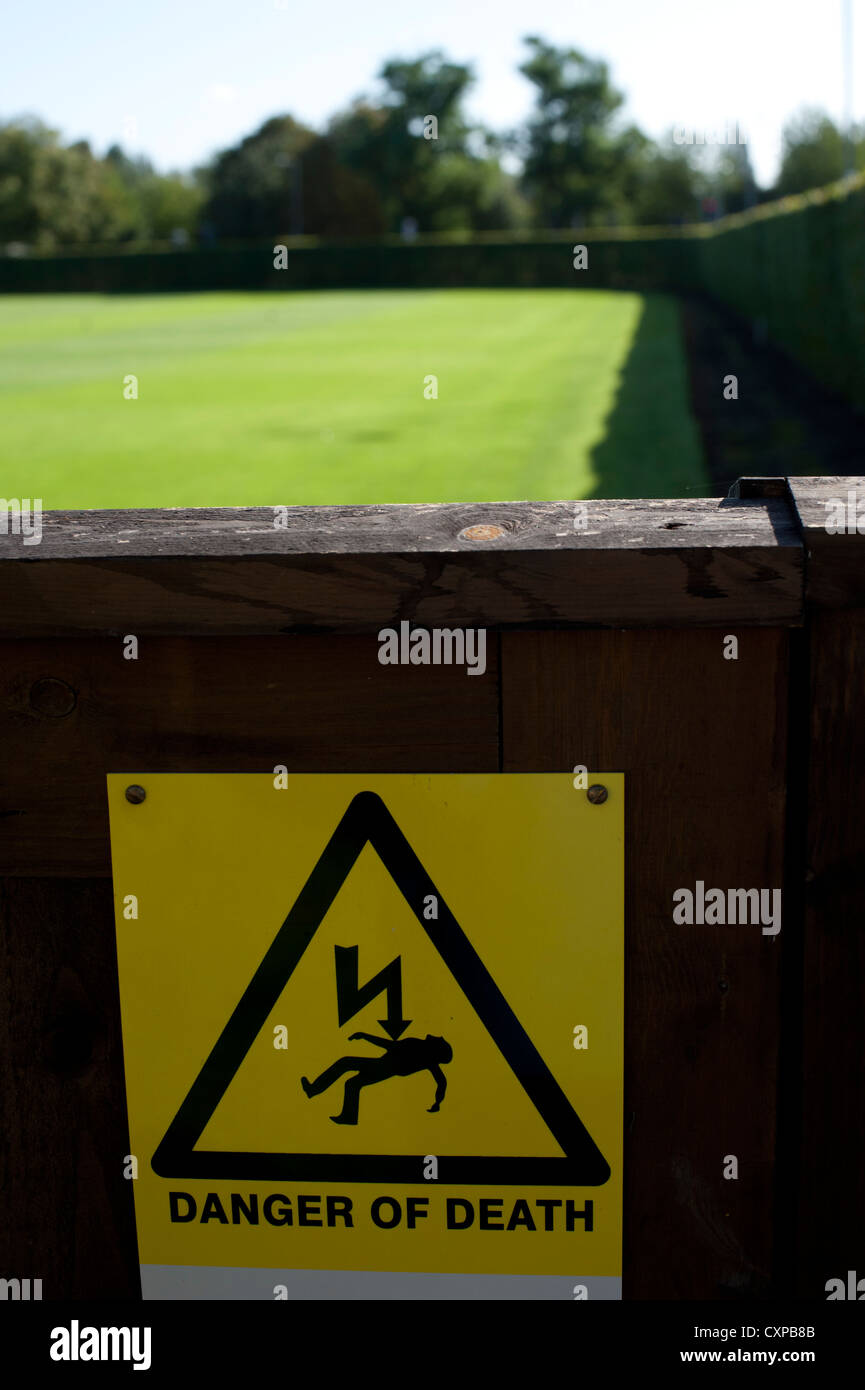 Sign on a wooden gate warning for danger of death upon entry to a green ...