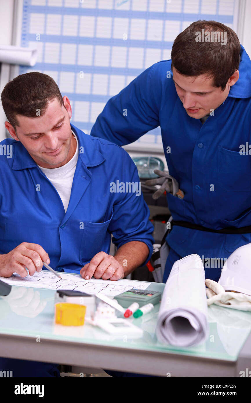 Workers looking at drawings Stock Photo - Alamy