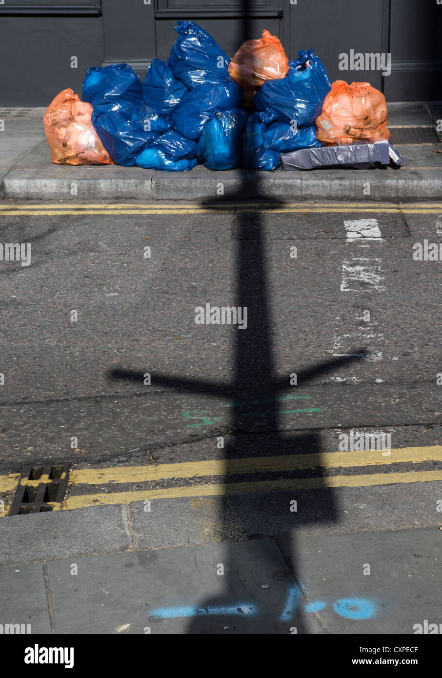The shadow of a lamp-post falling across an empty street, and over a ...