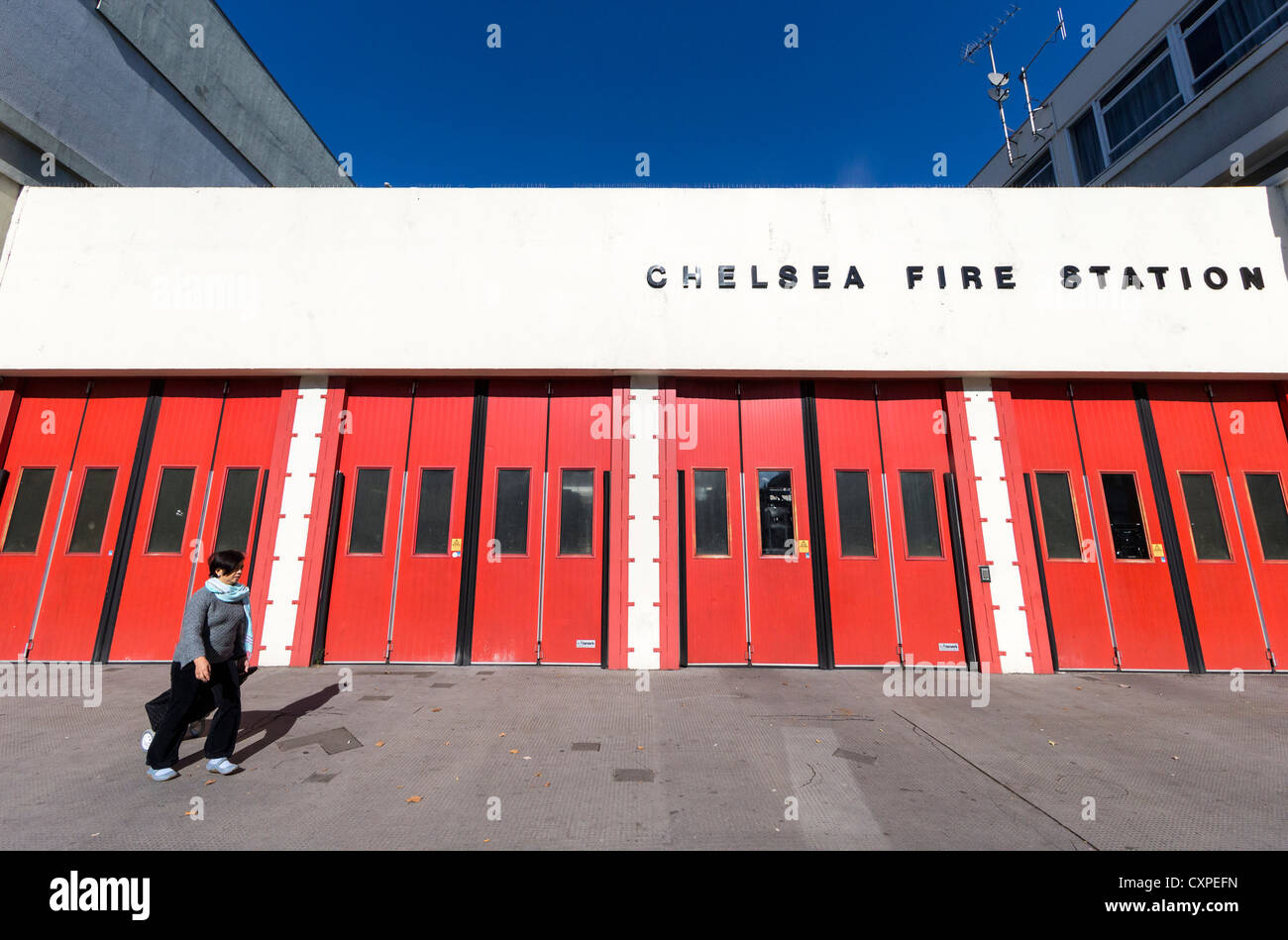 A woman walking past the red doors of Chelsea Fire Station in London's ...
