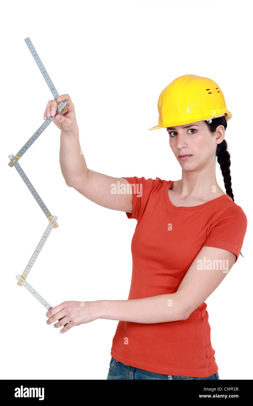 Construction worker holding a ruler Stock Photo - Alamy