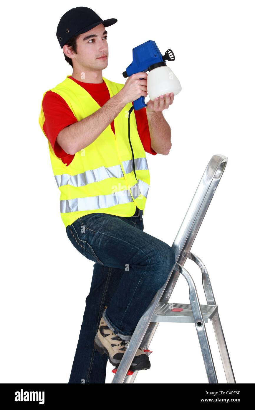 Young laborer on a ladder with spray Stock Photo - Alamy