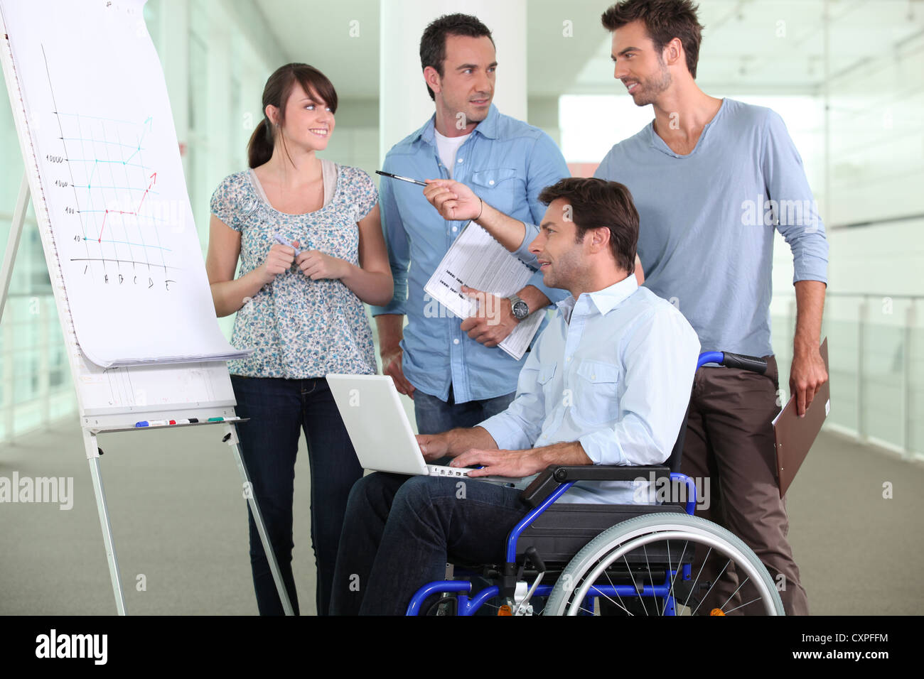Man in a wheelchair working in an office Stock Photo - Alamy