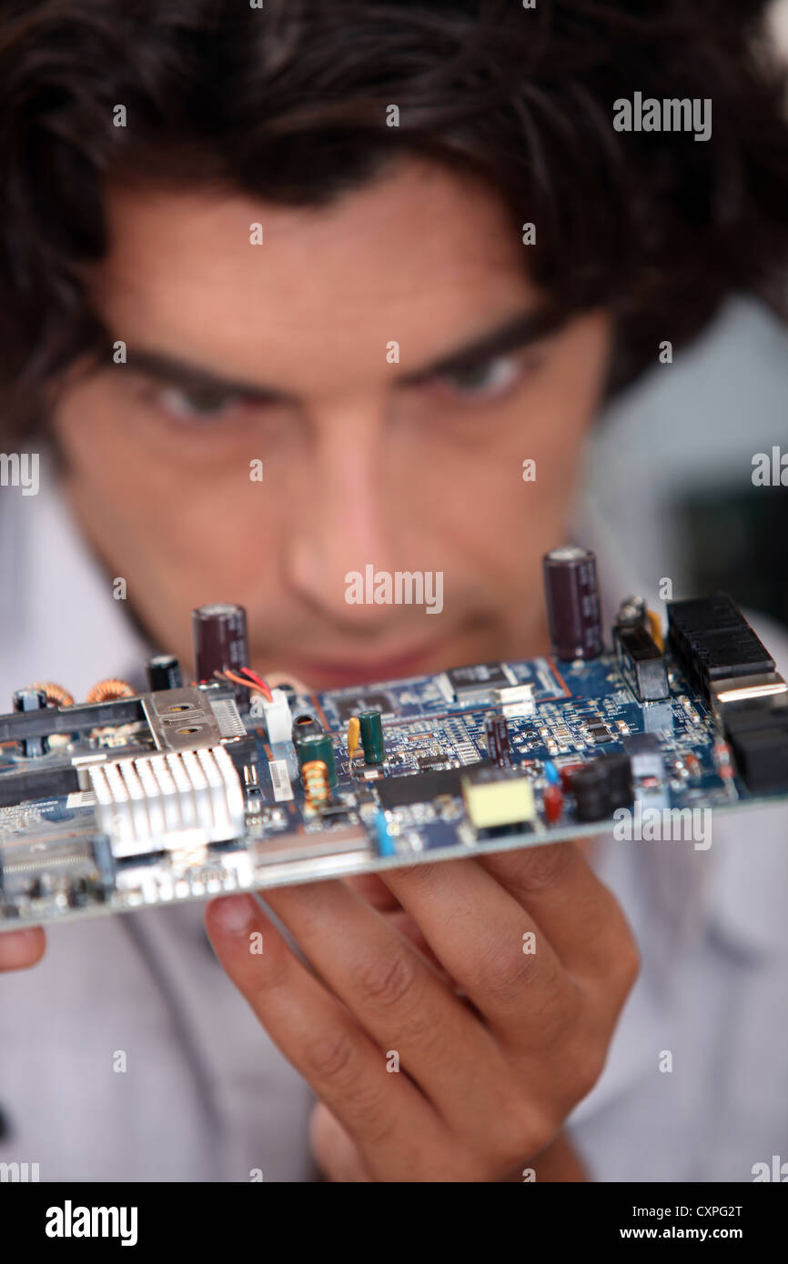Man looking at an electronic board Stock Photo - Alamy