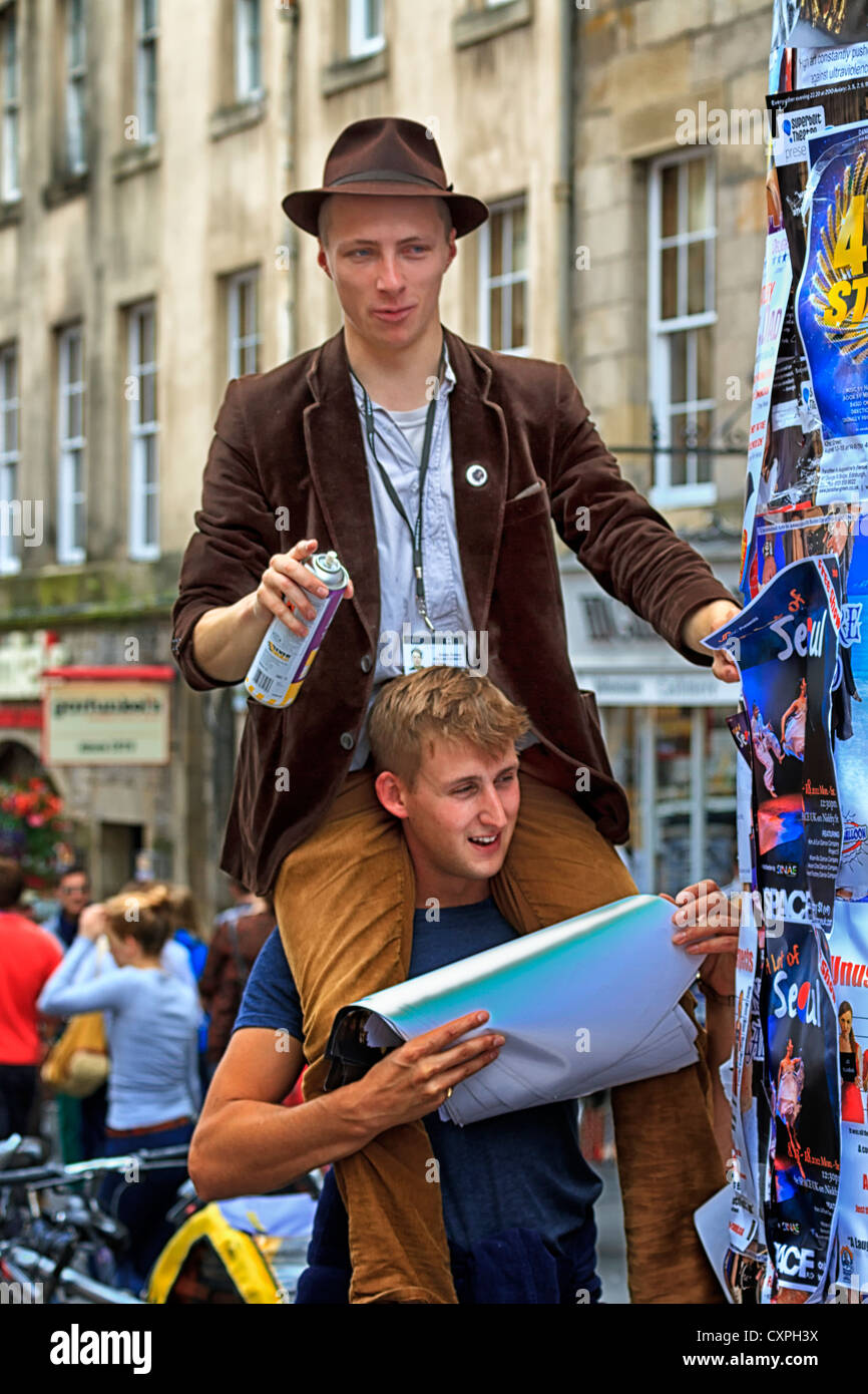 Two young men putting up posters, Edinburgh Fringe Festival, Scotland ...