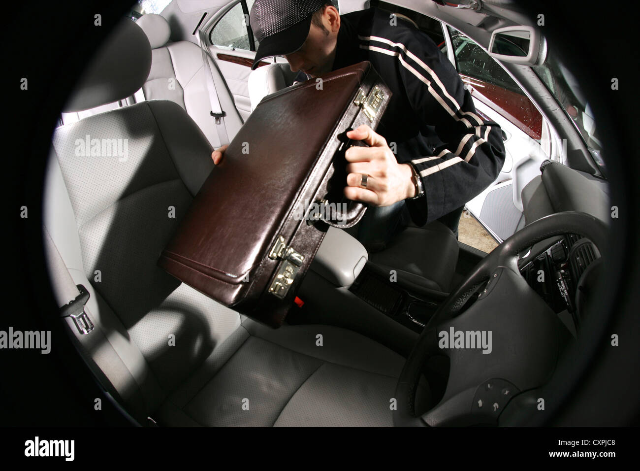 Thief stealing briefcase out of car Stock Photo - Alamy