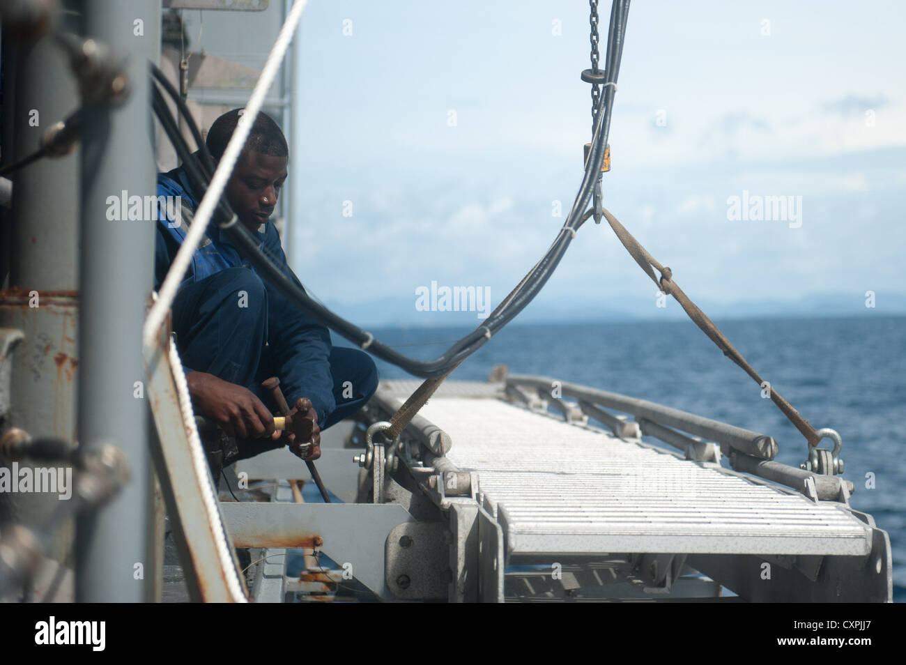 Seaman Dwayne Purnell, aboard the USS Mobile Bay (CG 53), attaches an ...