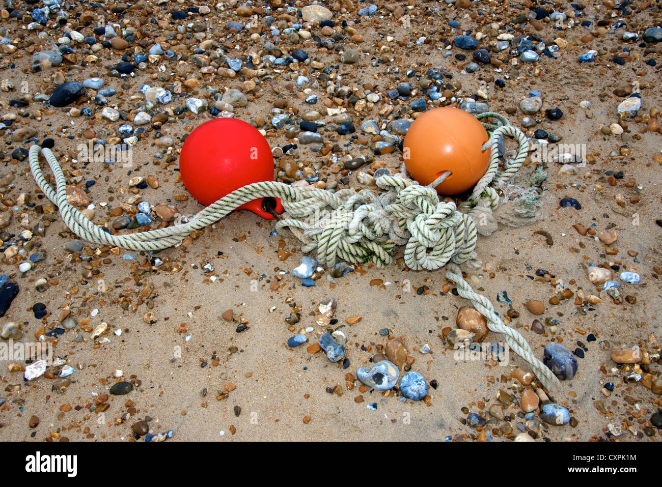 Tied and tide. Two floats and ropes in the shingle of a beach at ...