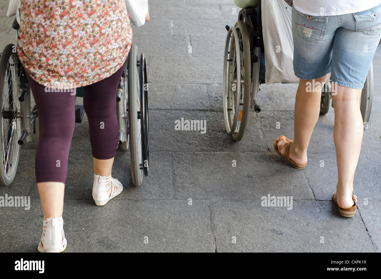 two people pushing two wheelchairs Stock Photo - Alamy