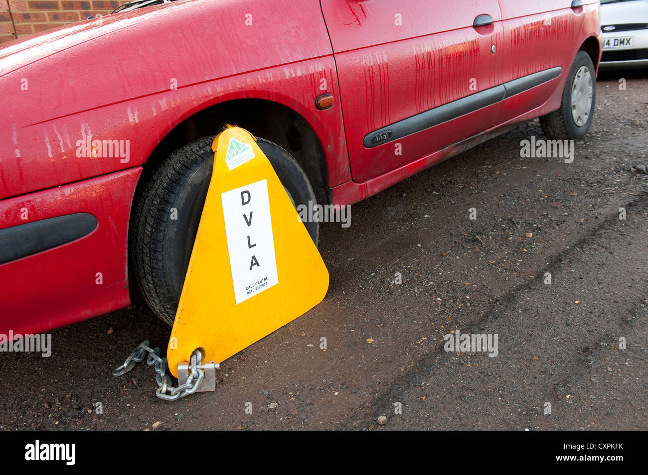 DVLA wheel clamp on a untaxed car parked on a street in England Stock ...