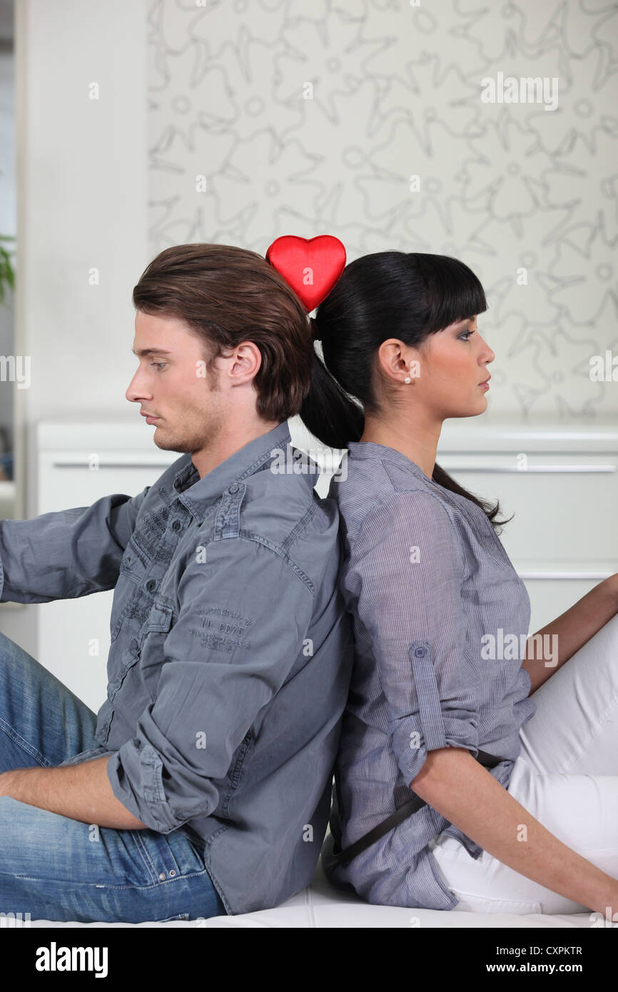 Young couple sat back to back Stock Photo - Alamy