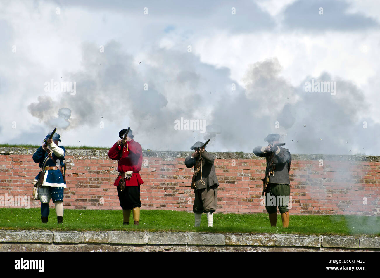Four old soldiers firing fuse lock rifles at an historic event at Fort ...