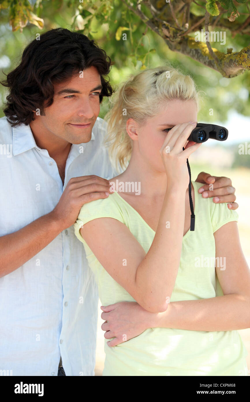 Couple using pair of binoculars Stock Photo - Alamy