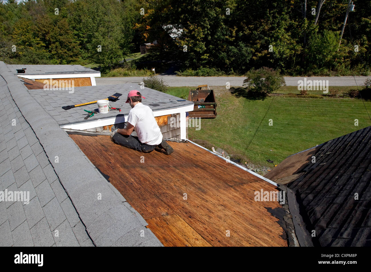 Man working on house roof, home repair Stock Photo - Alamy