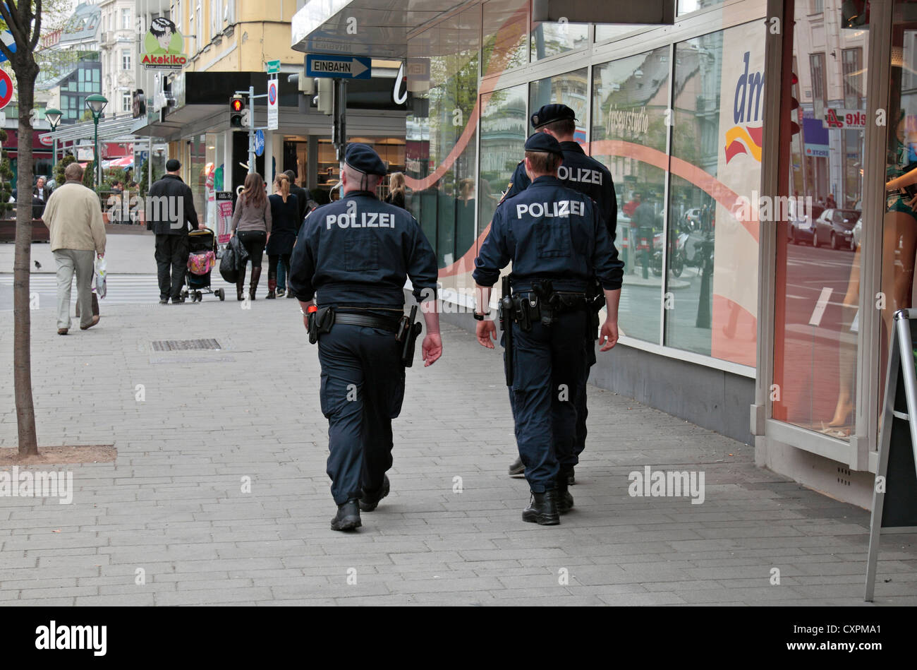 Three armed Austrian Police (Polizei) officers walking along the ...
