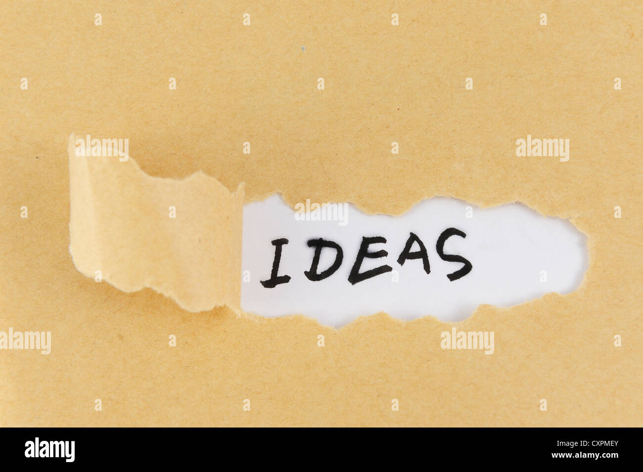 Torn paper with ideas word behind it Stock Photo - Alamy