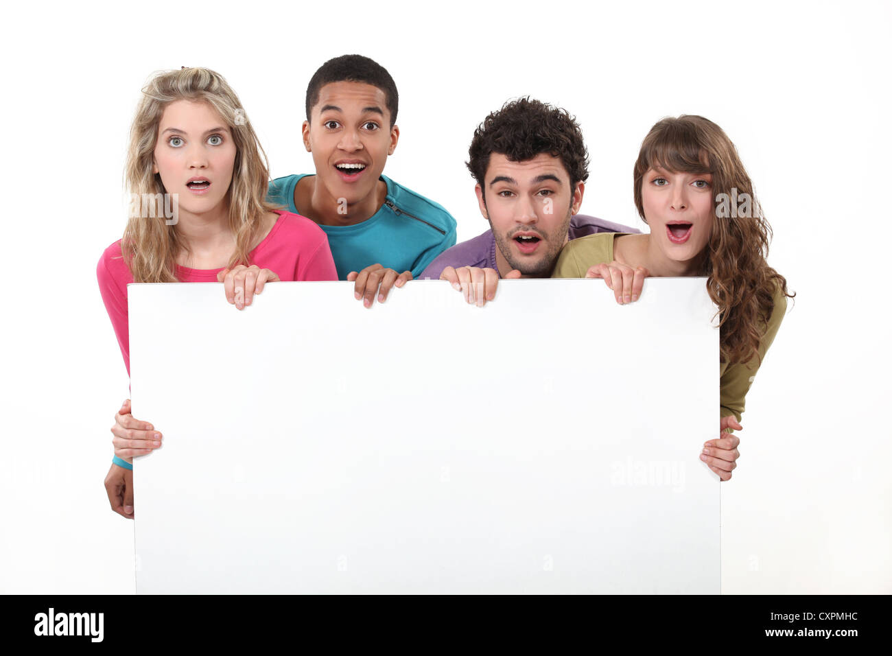 Young people standing behind a blank sign Stock Photo - Alamy