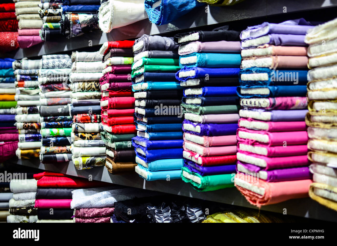Various textile materials on shelves Stock Photo - Alamy