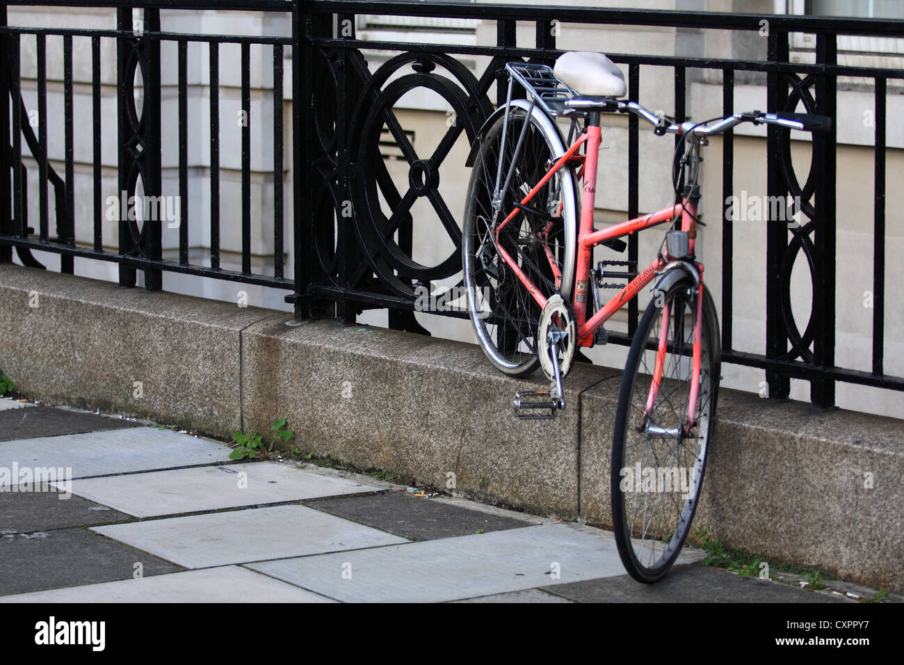 a cycle chained to railings in London Stock Photo - Alamy