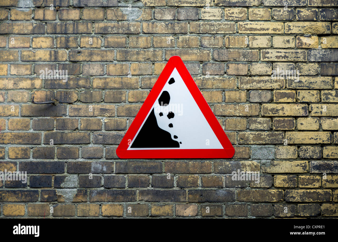 Yellow brick wall with triangle sign Stock Photo - Alamy