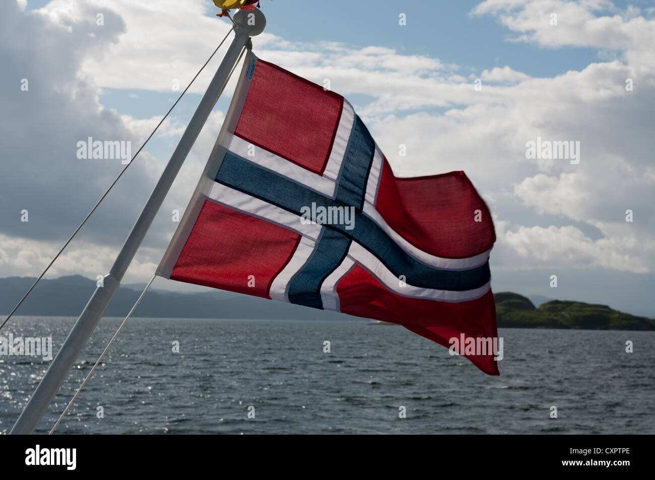 The Norwegian Flag flying in the wind on the back of a passenger boat ...
