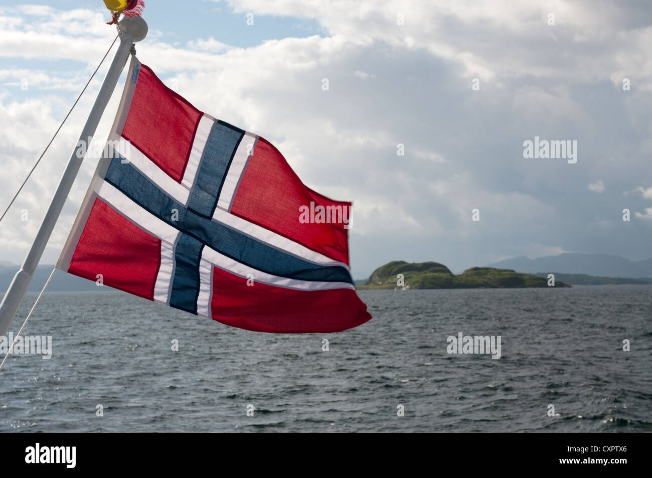 The Norwegian Flag flying in the wind on the back of a passenger boat ...