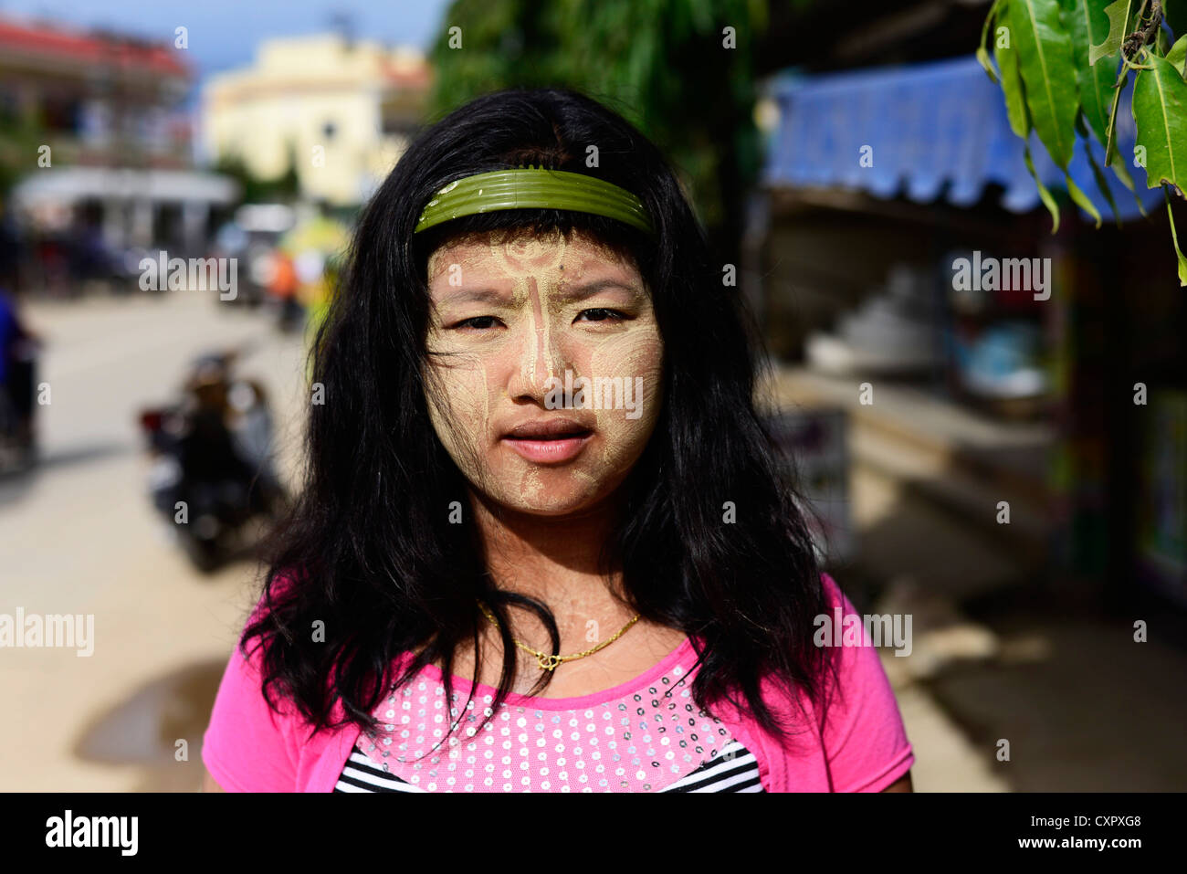 A Burmese girl wearing Thanaka ( yellow powder makeup ) on her face ...