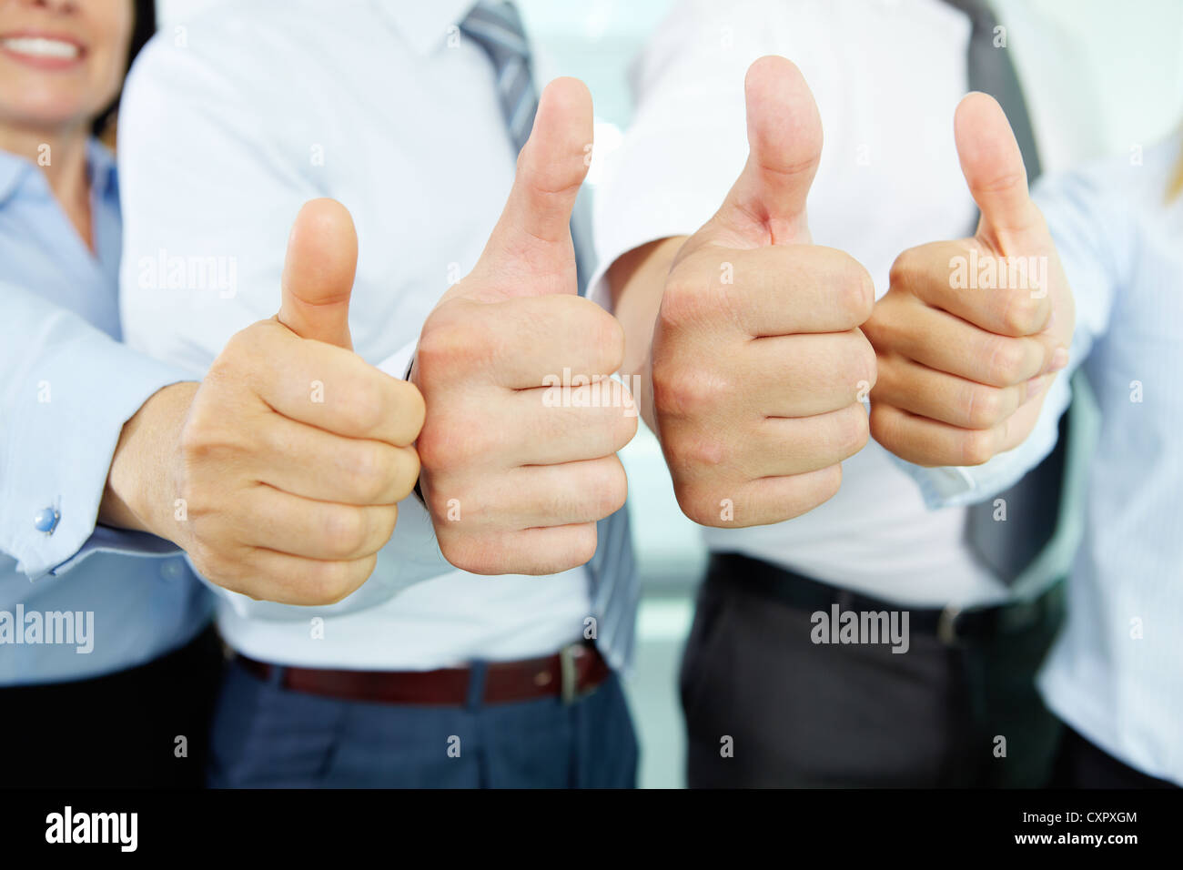 Close-up of business team holding their thumbs up Stock Photo - Alamy