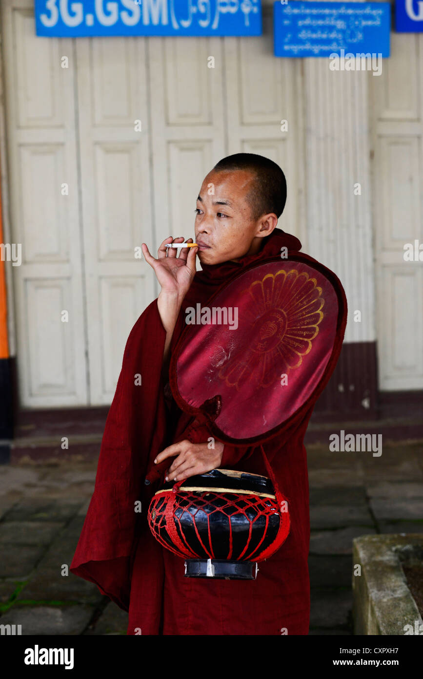 A Buddhist monk enjoys smoking a cigarette Stock Photo - Alamy