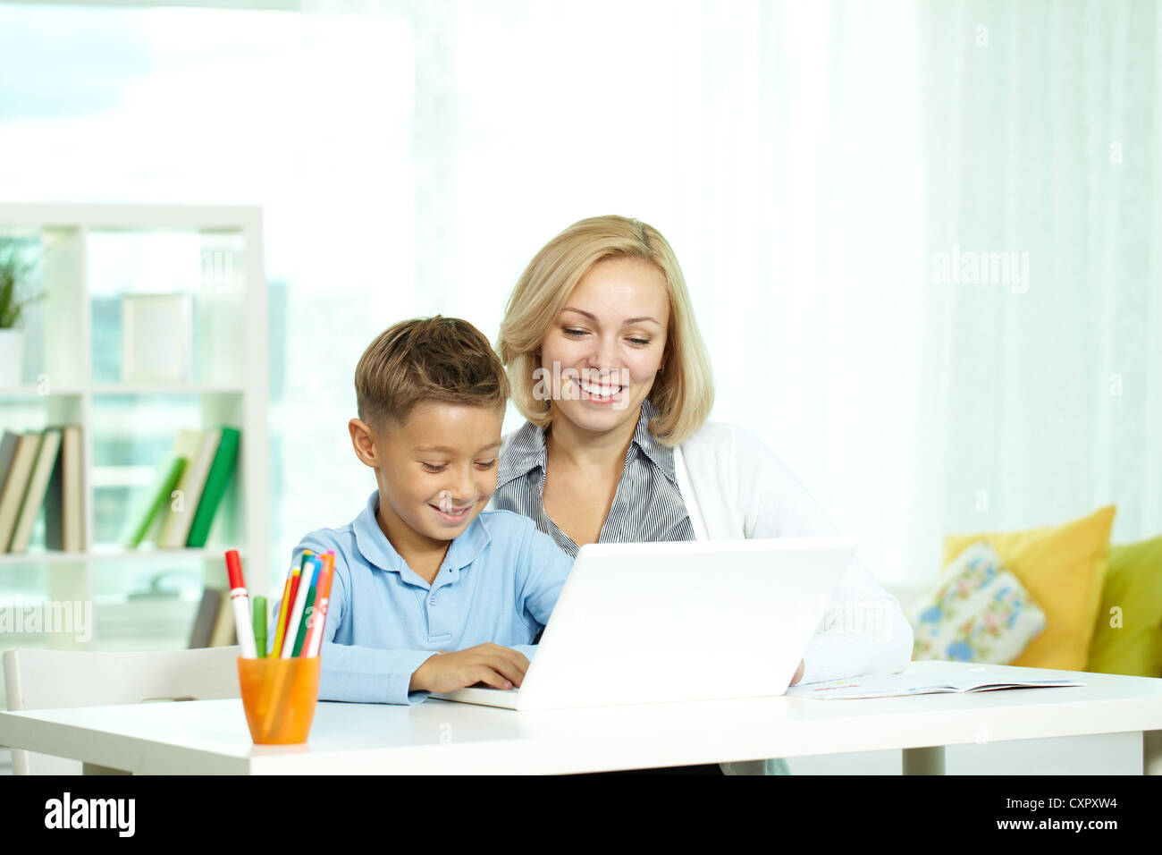 Portrait of pretty tutor and her pupil working with laptop Stock Photo ...