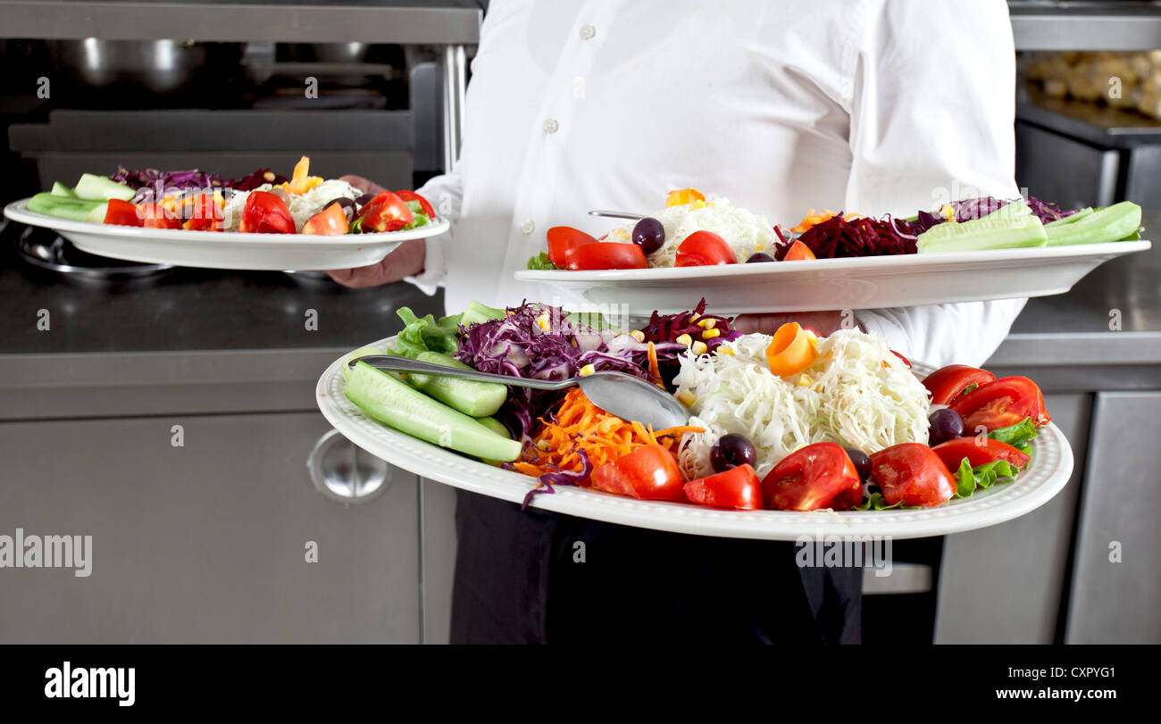 Waiter carrying plates with salad Stock Photo - Alamy