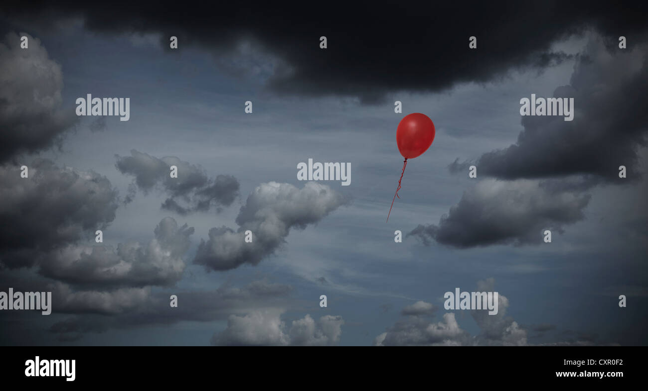 Red balloon floating through dark sky Stock Photo - Alamy