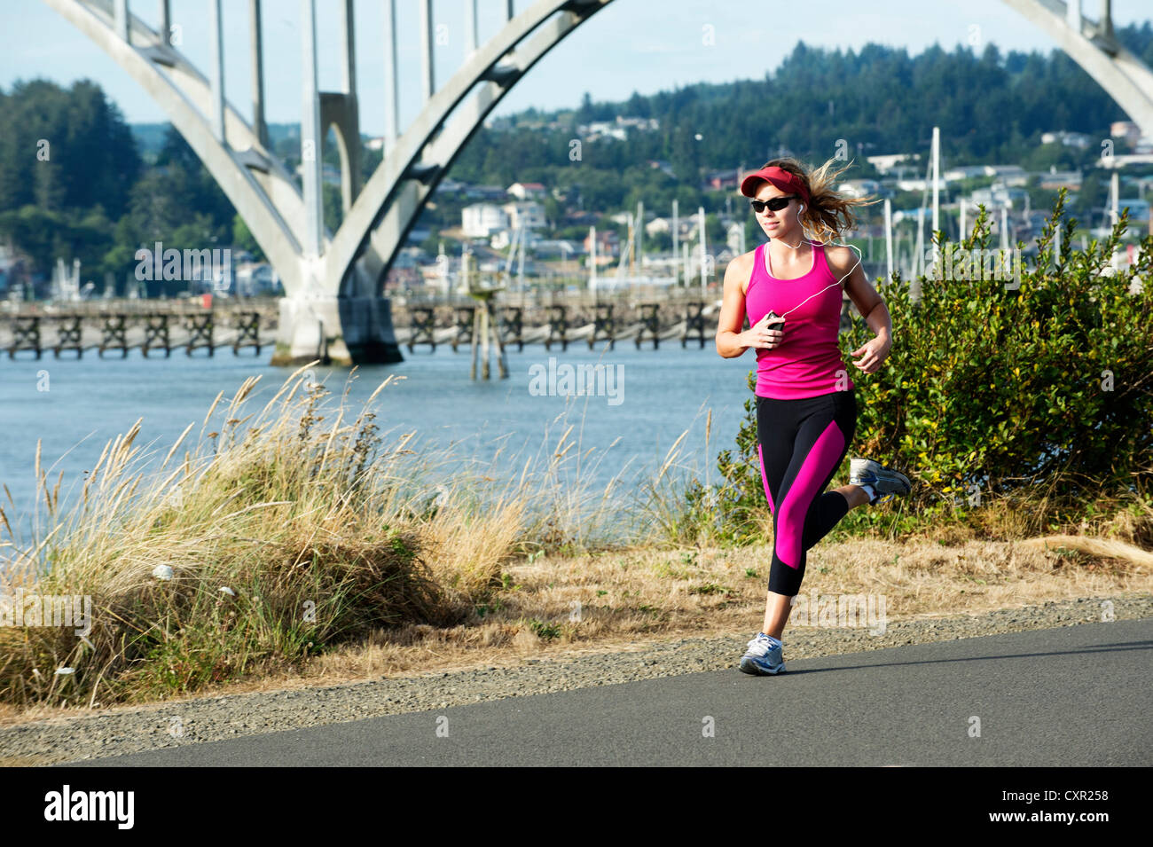 Young woman running on path near the sea Stock Photo - Alamy