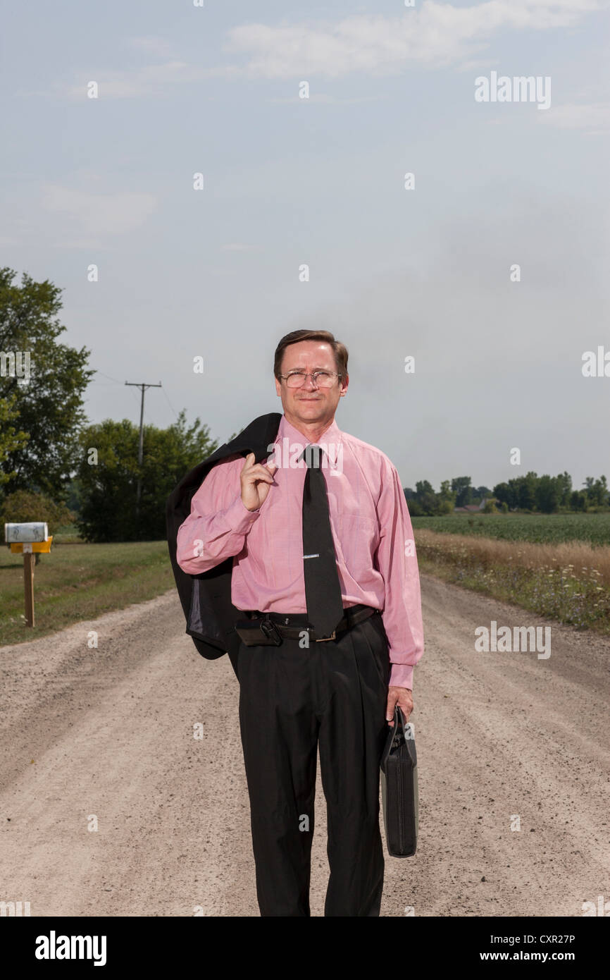 Businessman on country road Stock Photo - Alamy
