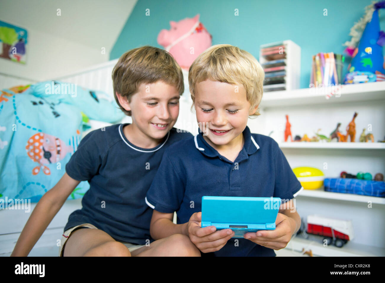 Brothers with handheld computer game Stock Photo - Alamy