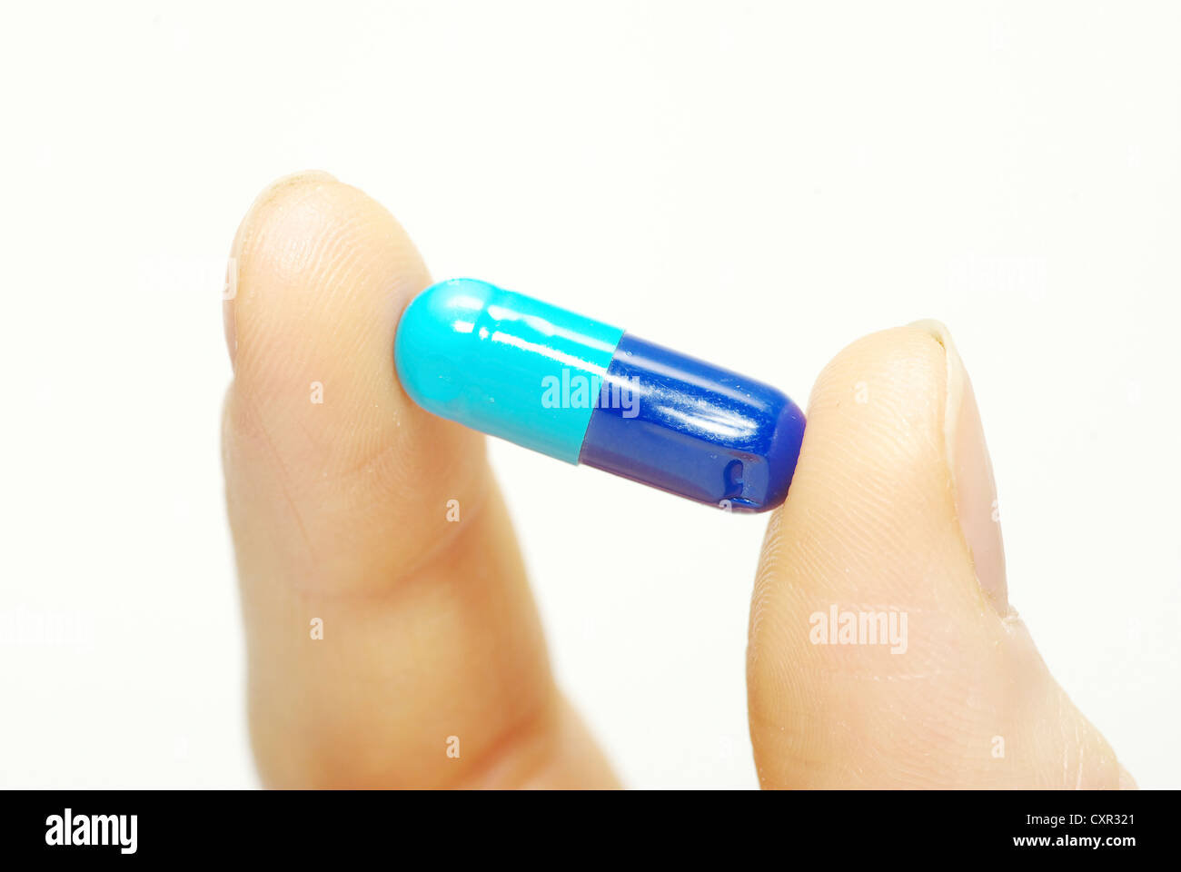 finger holds pill isolated on white Stock Photo - Alamy