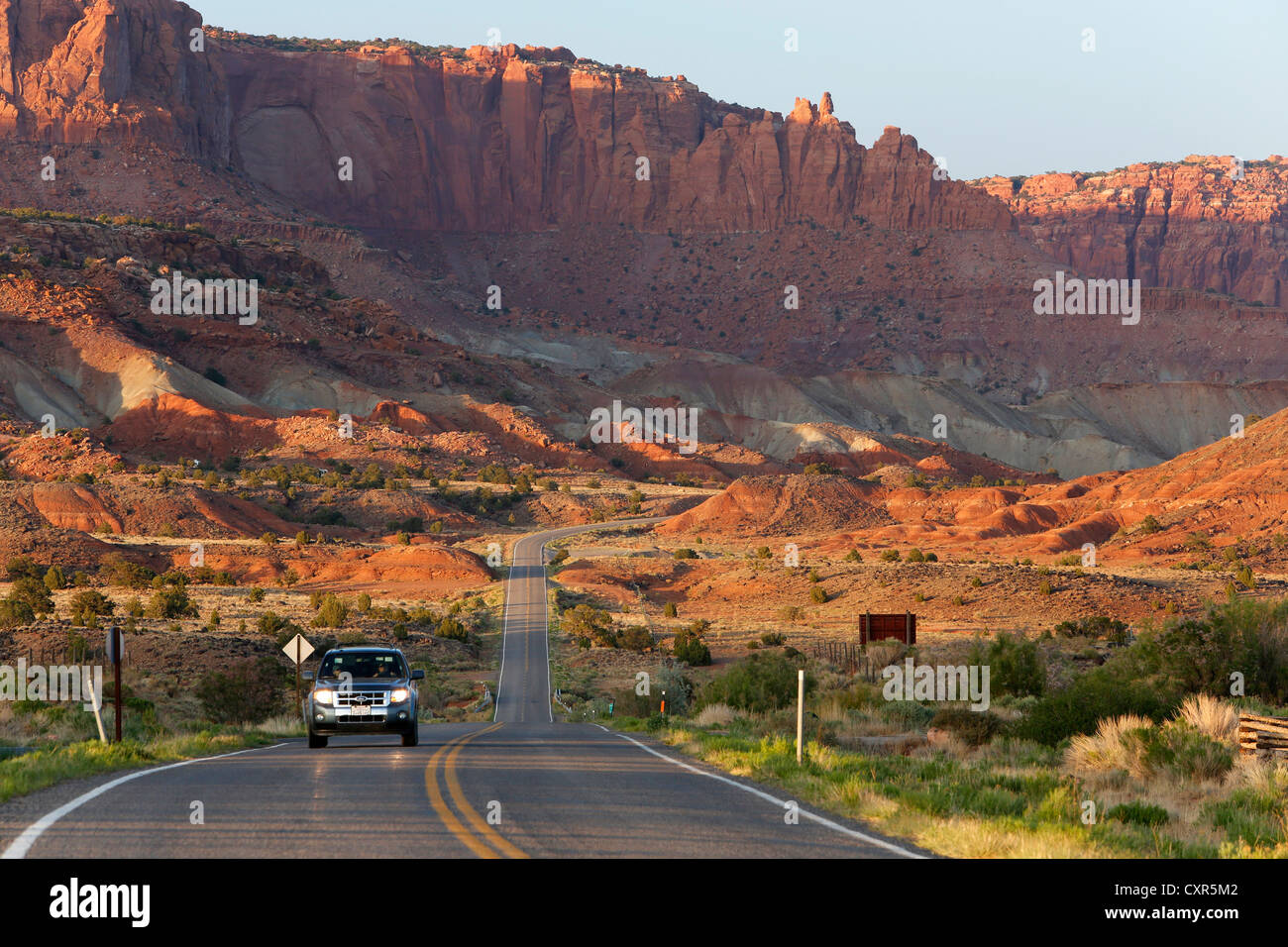 Car in front of the Capitol Reef rock formation on a public road ...