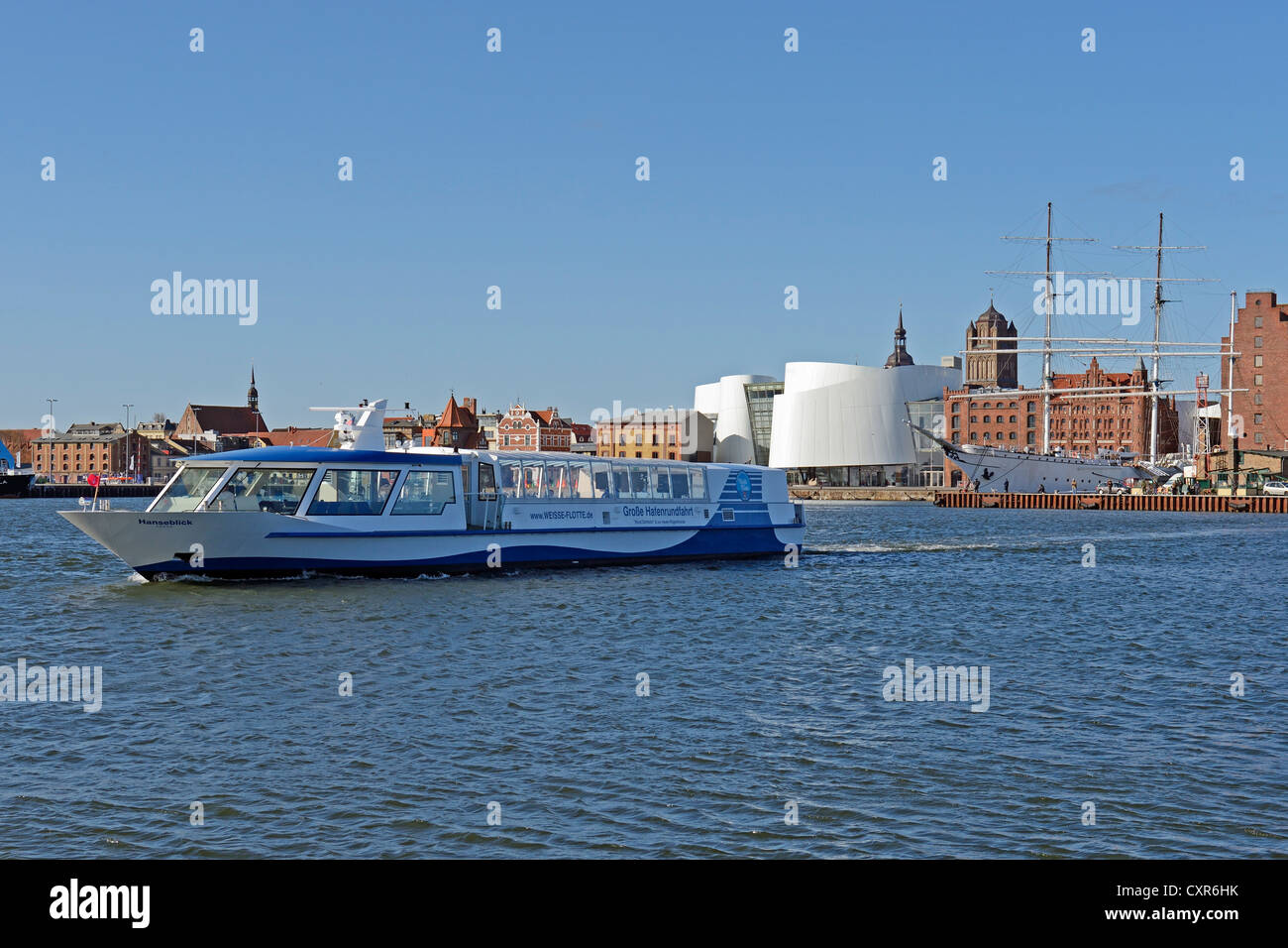 View of a pleasure boat, historic storage buildings and Ozeaneum museum ...