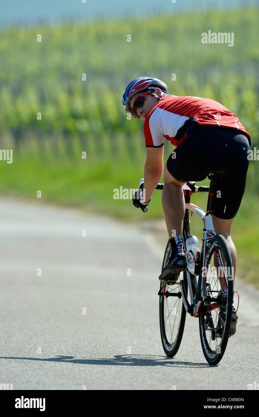 Cyclist riding a high-quality carbon road bike, looking backwards ...