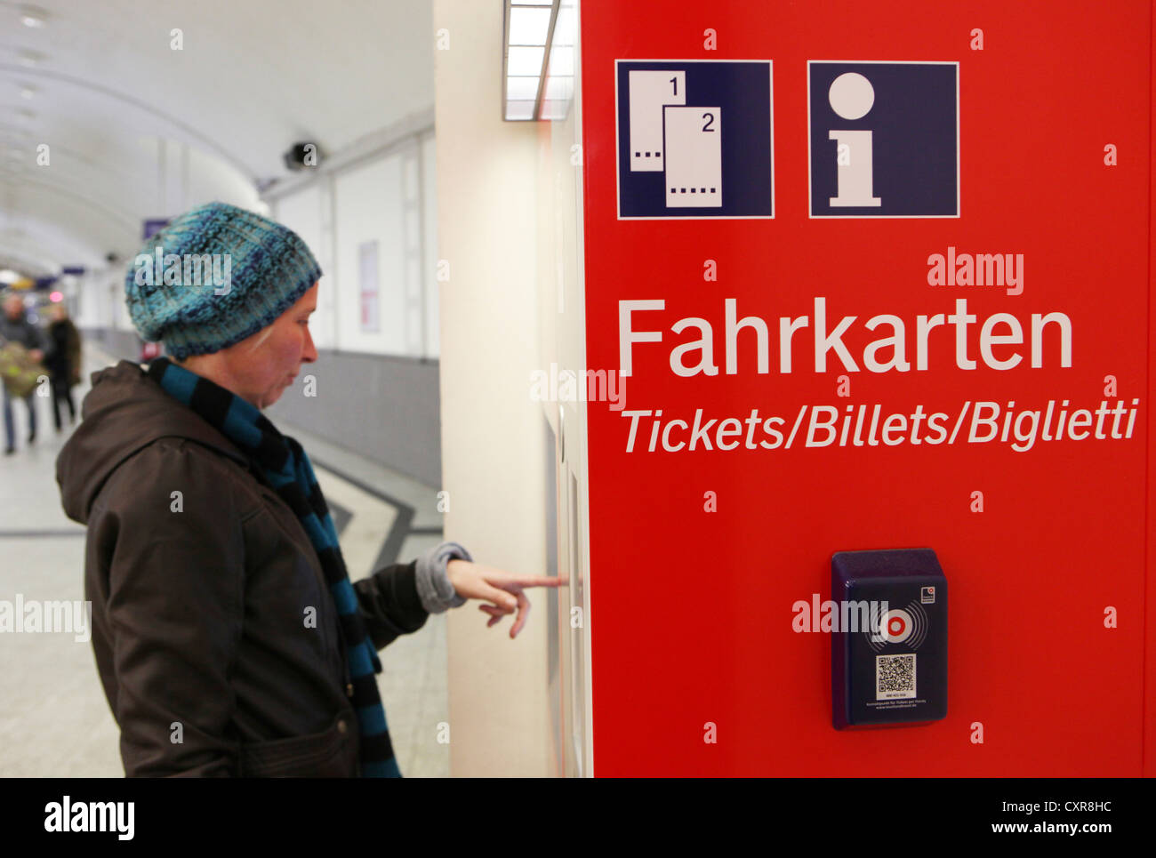 Woman buying a ticket at a ticket vending machine at Deutz train ...