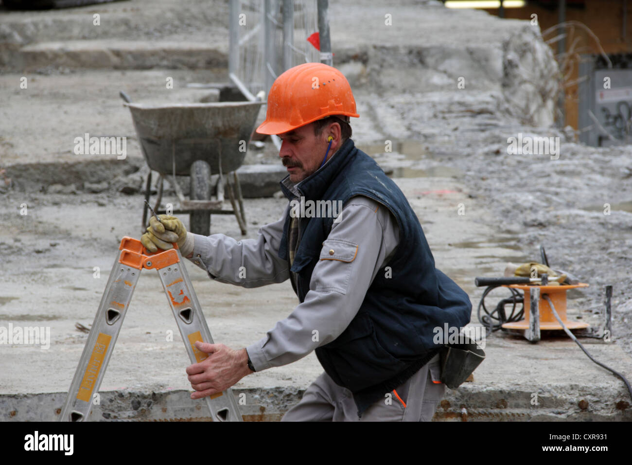 Construction worker climbing onto a concrete slab to work there Stock ...