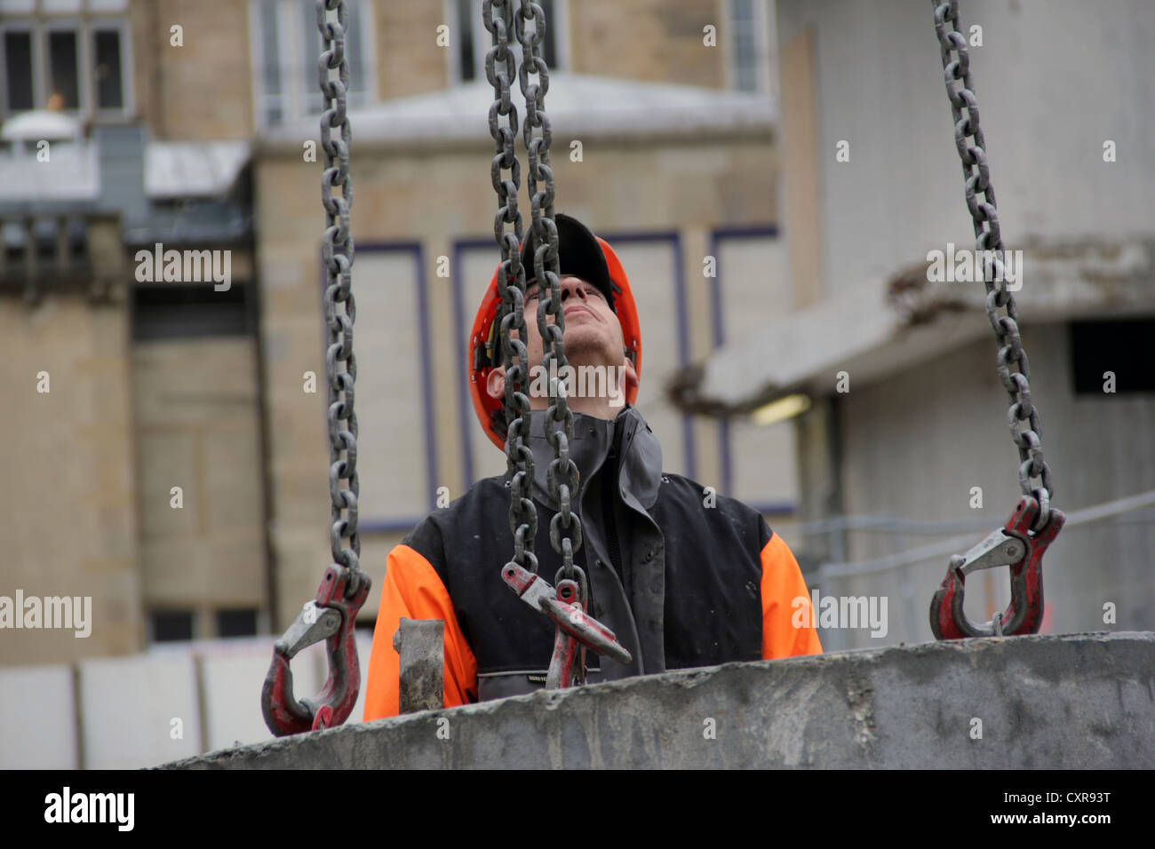 Construction worker controlling a construction crane lifting a piece of ...
