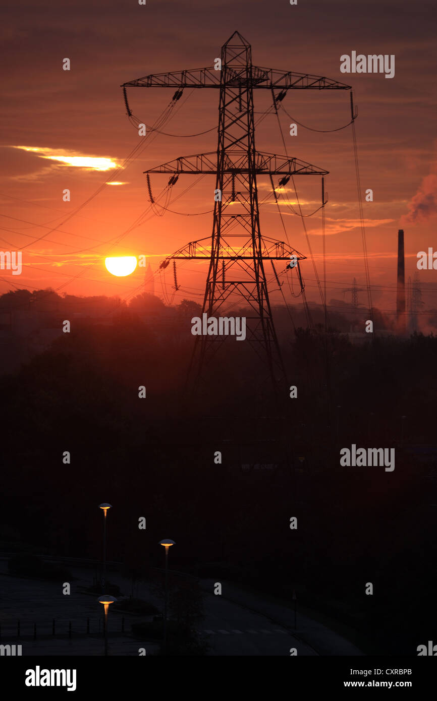 Electricity pylons against a morning sunrise Stock Photo - Alamy