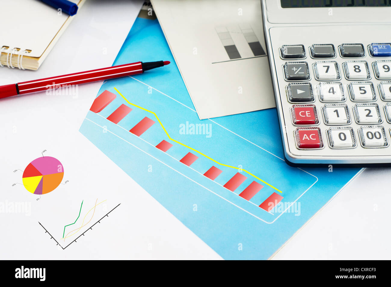 Pen and calculator on paper table with diagram Stock Photo - Alamy