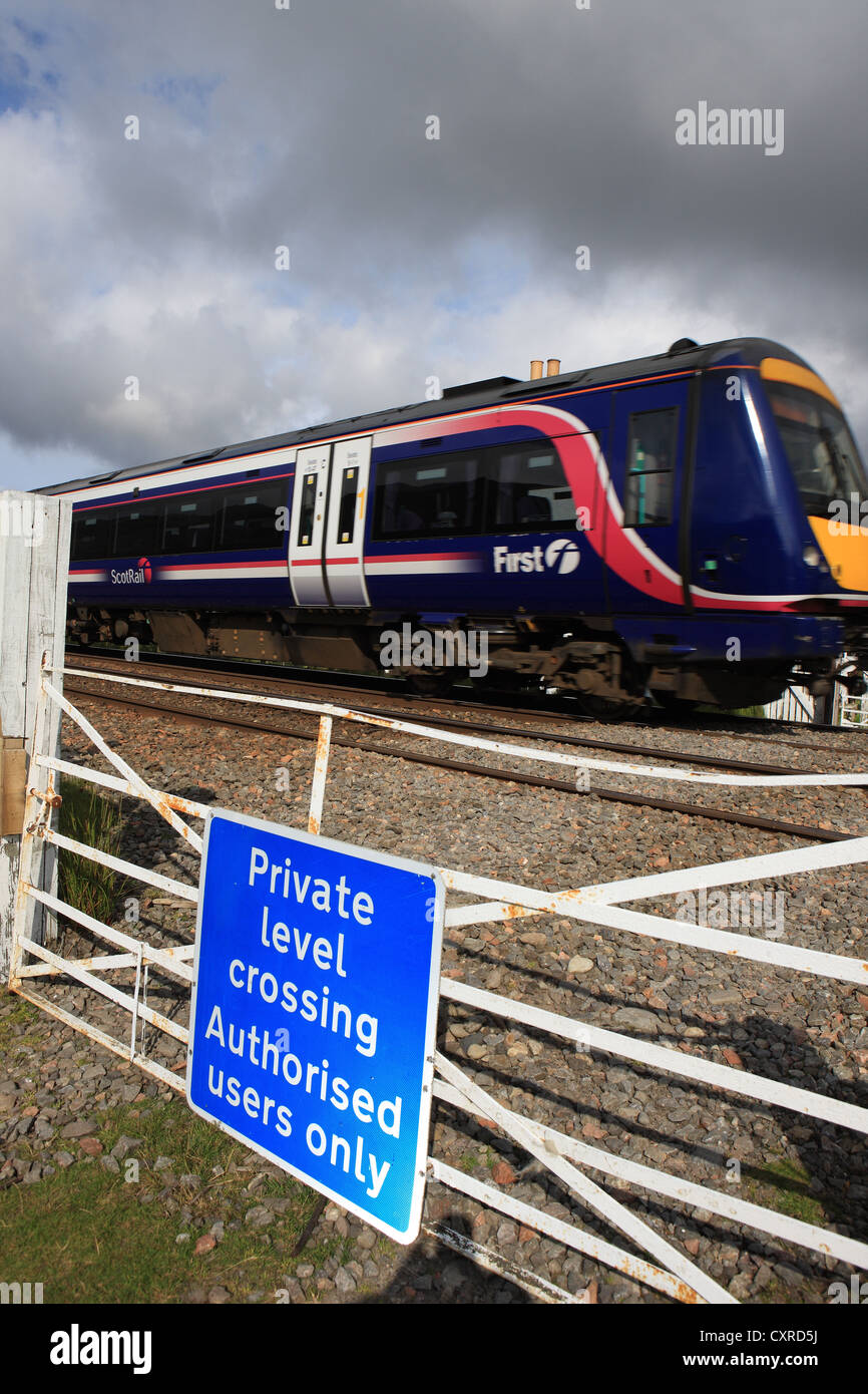 Train crossing an unmanned level crossing in the Highlands of Scotland ...