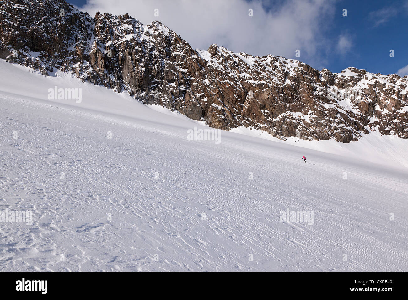Solitary cross-country skier in front of a cliff, Stubai Alps, Tyrol ...