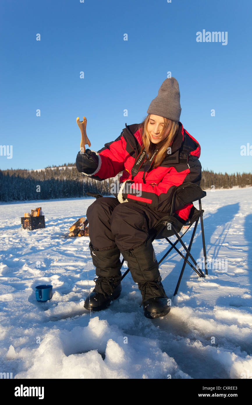 Young woman, ice fishing, Hidden Lake near Whitehorse, Yukon Territory ...
