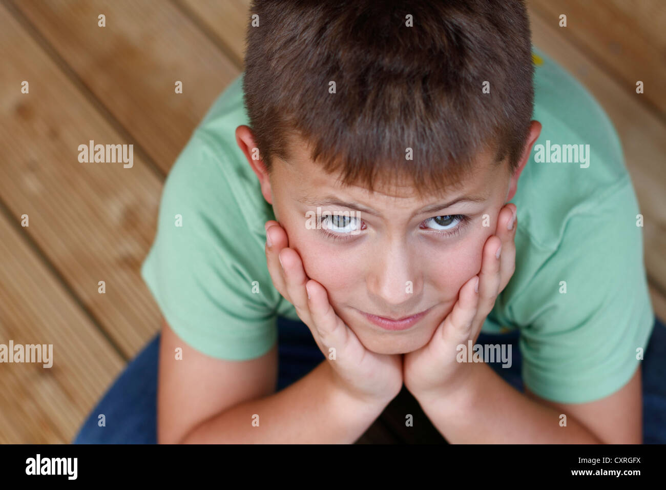 Boy sitting on a wooden floor, view from above Stock Photo - Alamy