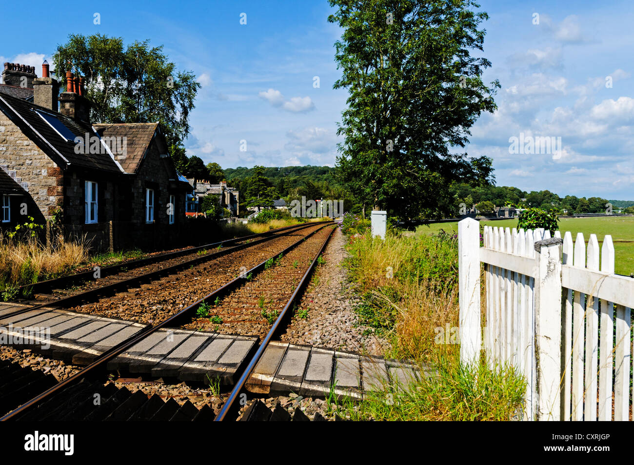 Railway lines lead away from a board provided as a pedestrian crossing ...